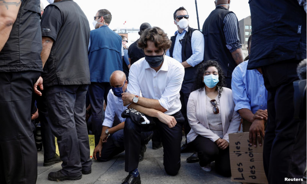 'Stand up to Trump!' Canada protesters shout to Trudeau who kneels at ...